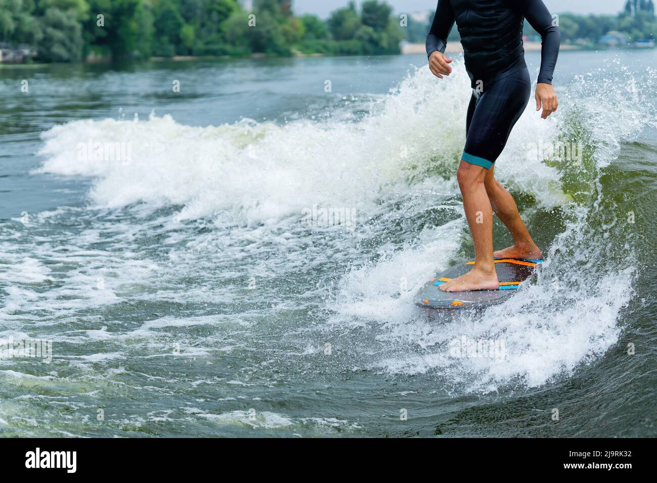 Wakeboarder riding a wakeboard on the river Stock Photo - Alamy