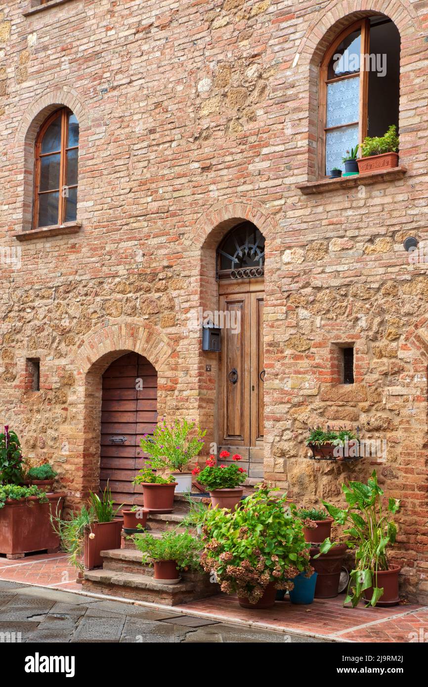 Italy, Tuscany, Pienza. Flower pots and potted plants decorate a narrow ...