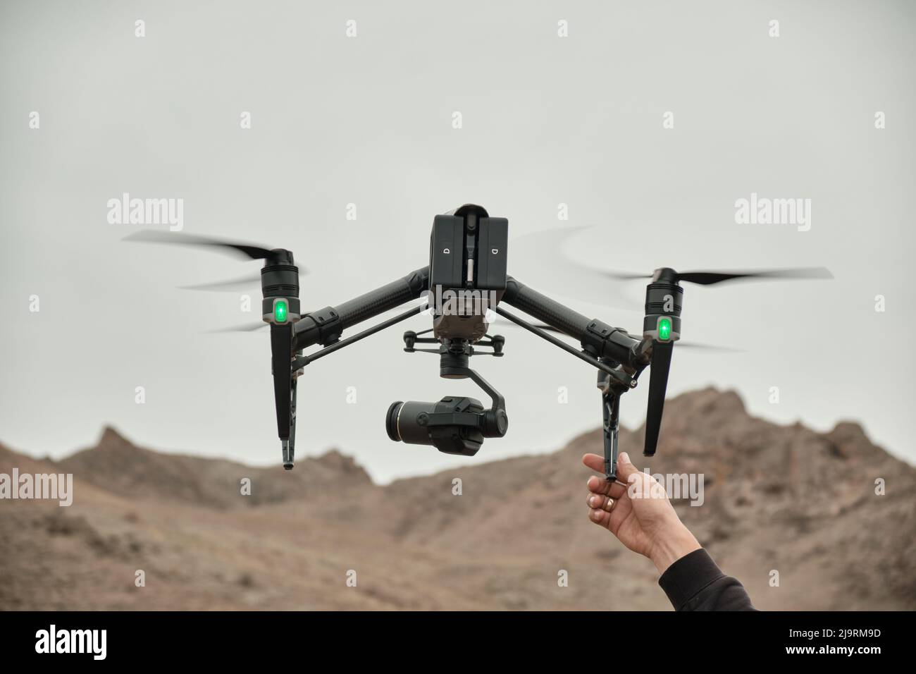 Men's hand catch a large professional drone, somewhere in the mountains ...