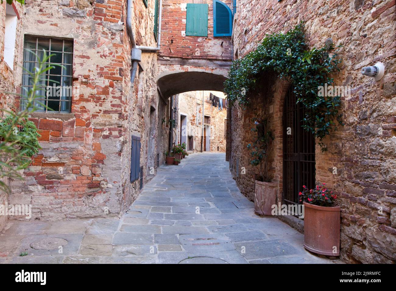 Italy, Tuscany, Crete Senesi, Asciano. Street scene with potted flowers ...