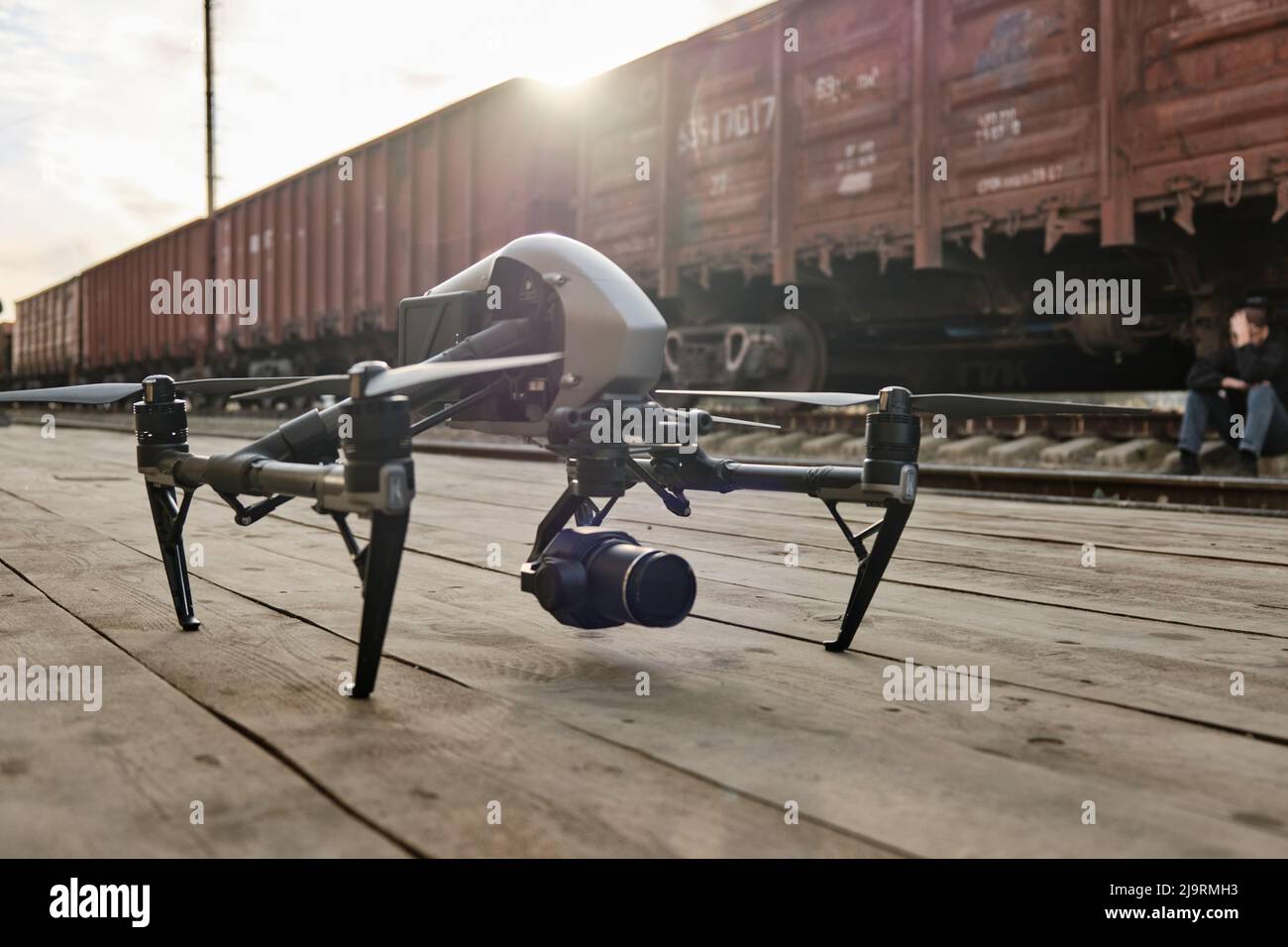 A professional drone stands on a wooden floor, preparing for flight ...