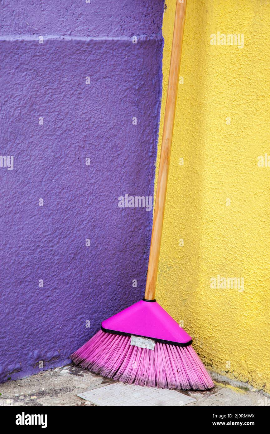 Italy, Venice, Burano Island. Pink broom in a colorful corner on the ...