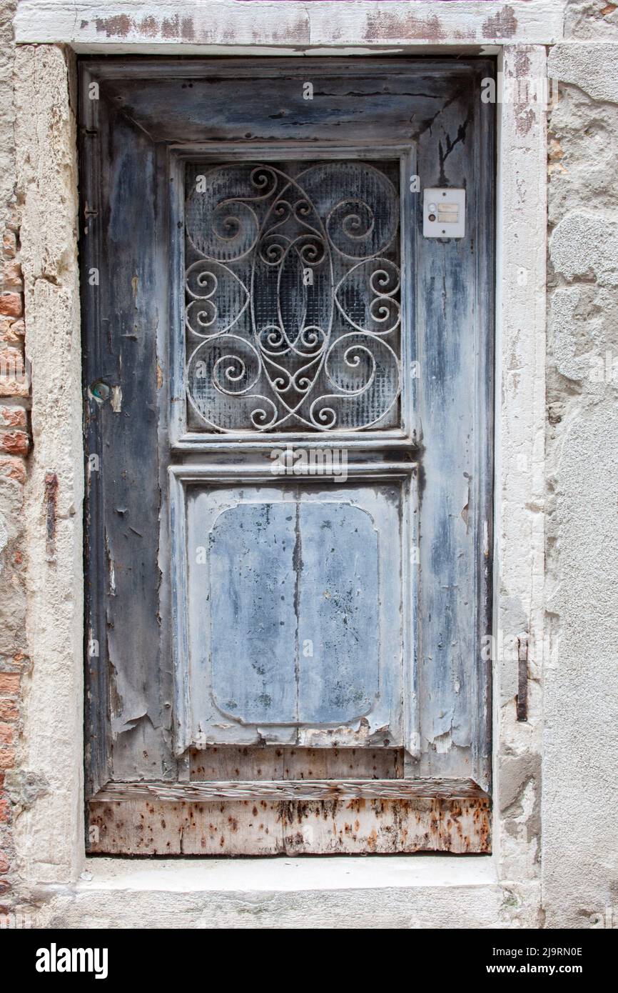 Italy, Venice. Old wooden blue door with metal design in the window ...