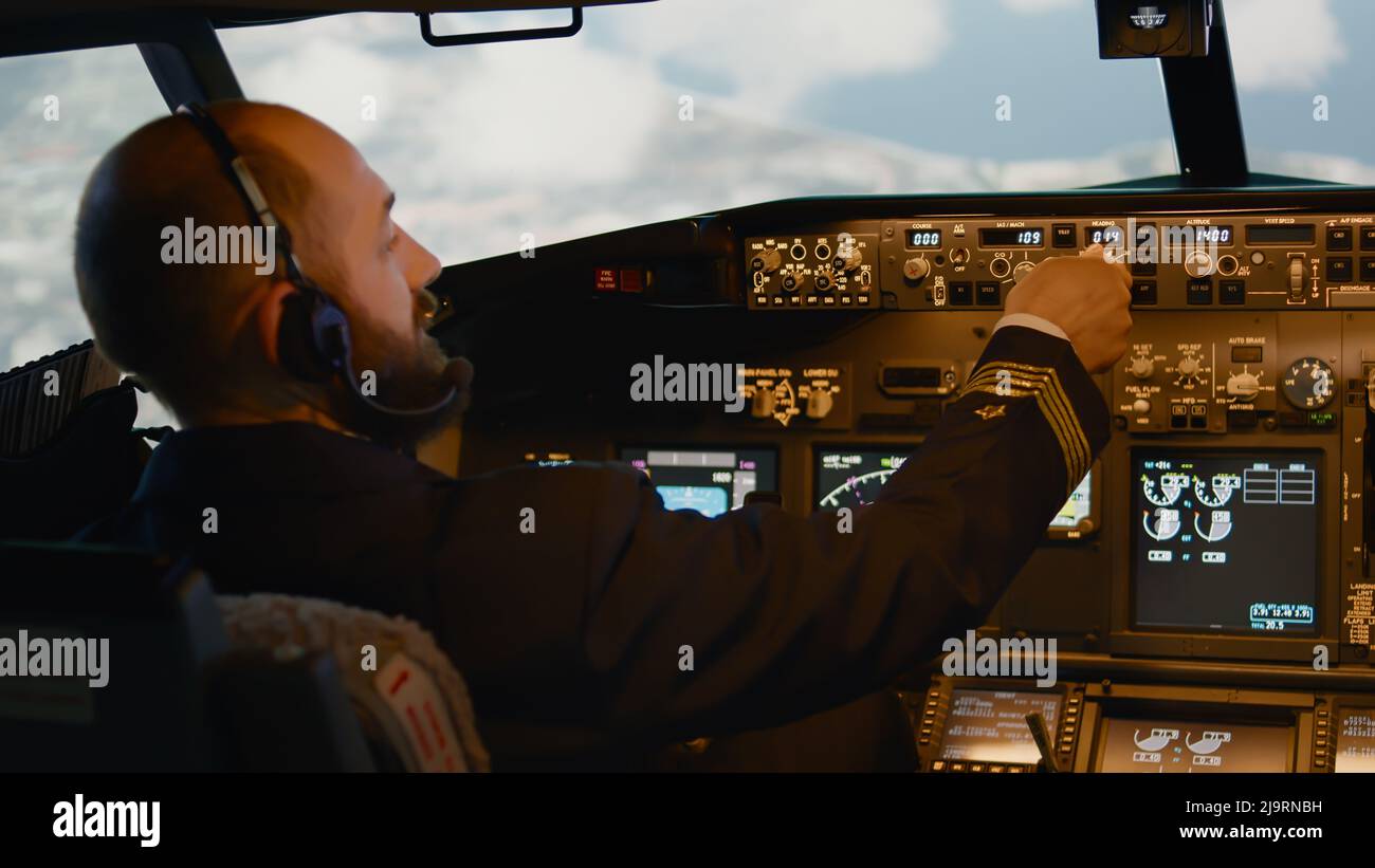Airline captain fixing altitude and longitude to fly airplane, using ...