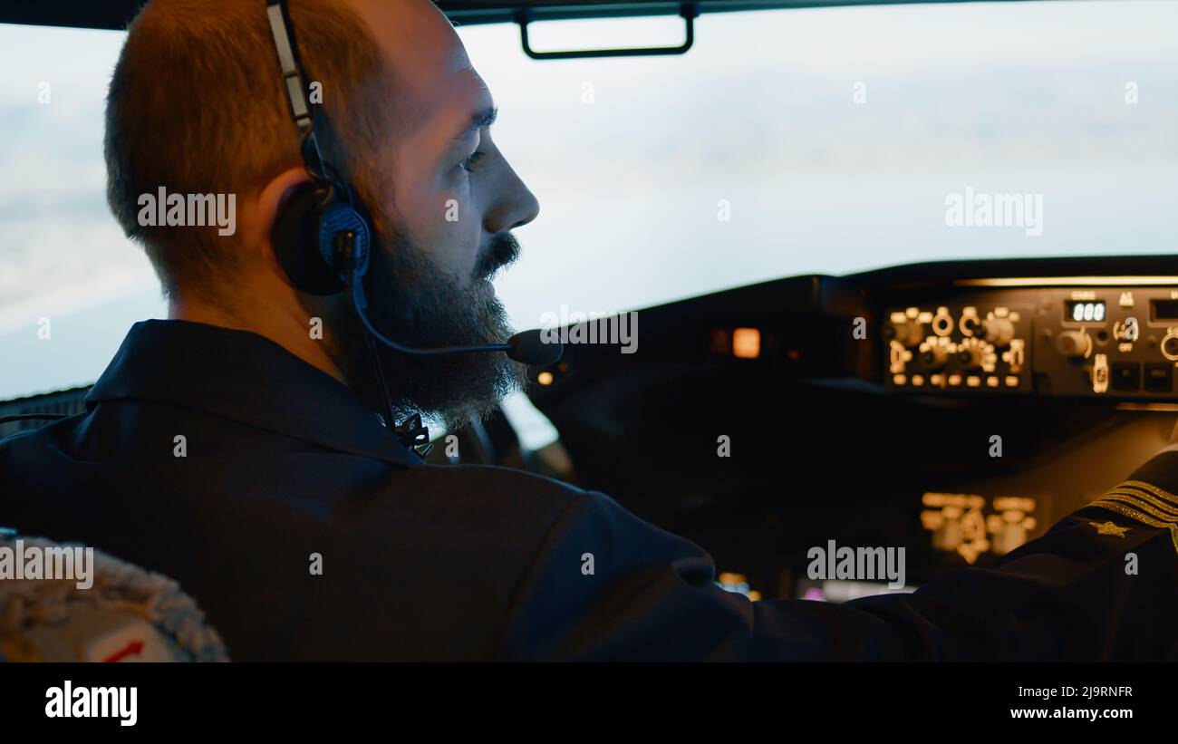 Male captain piloting airplane with engine throttle and power switch on ...