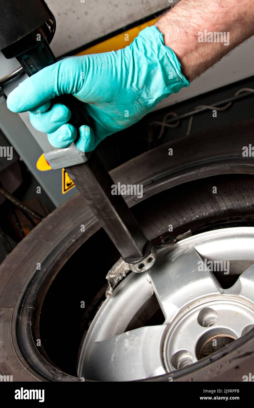 Mechanic changing car wheel in auto repair shop Stock Photo - Alamy