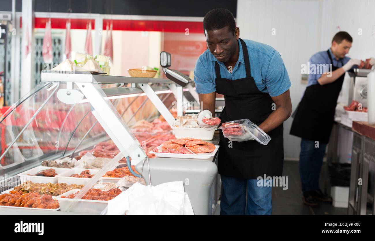 Butcher arranging meat display hi-res stock photography and images - Alamy