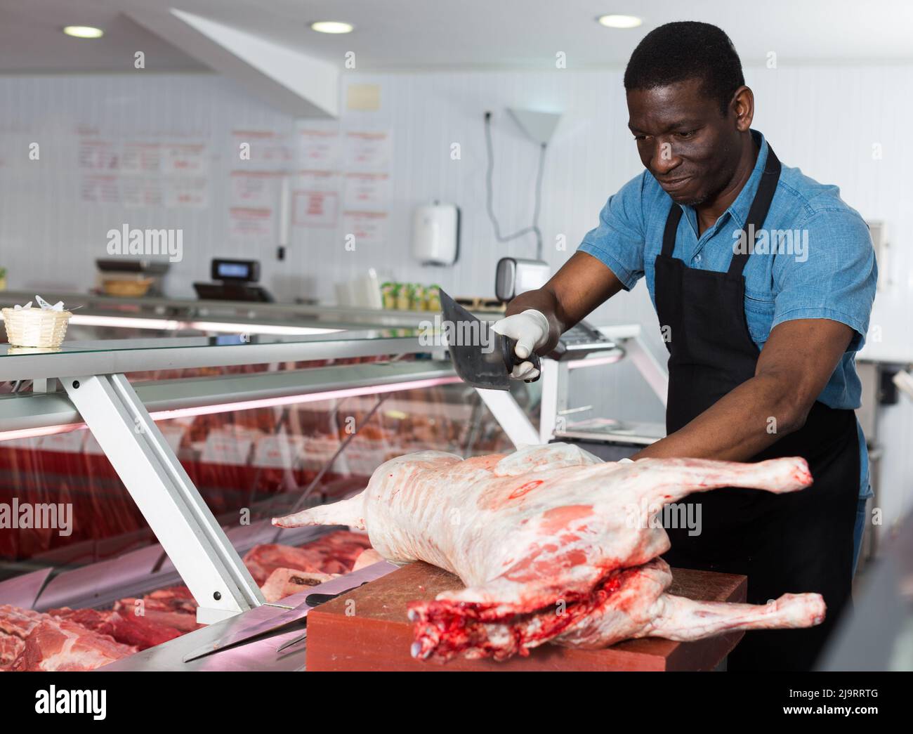 Butcher processing carcase of lamb Stock Photo - Alamy