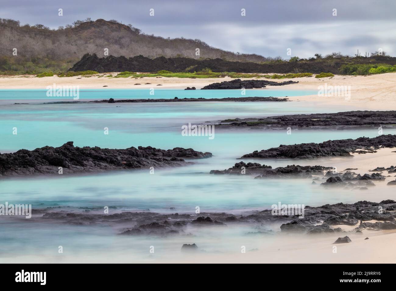 Lava rocks along tranquil shoreline of San Cristobal Island, Galapagos ...