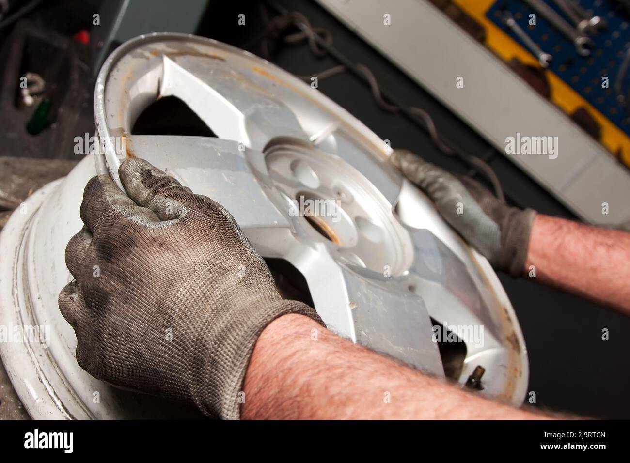 Mechanic changing car wheel in auto repair shop Stock Photo - Alamy
