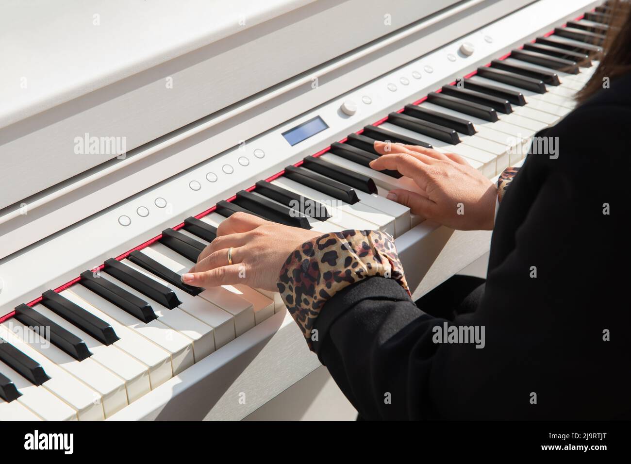 Hands of a female artist playing the piano. Woman pianist making music ...