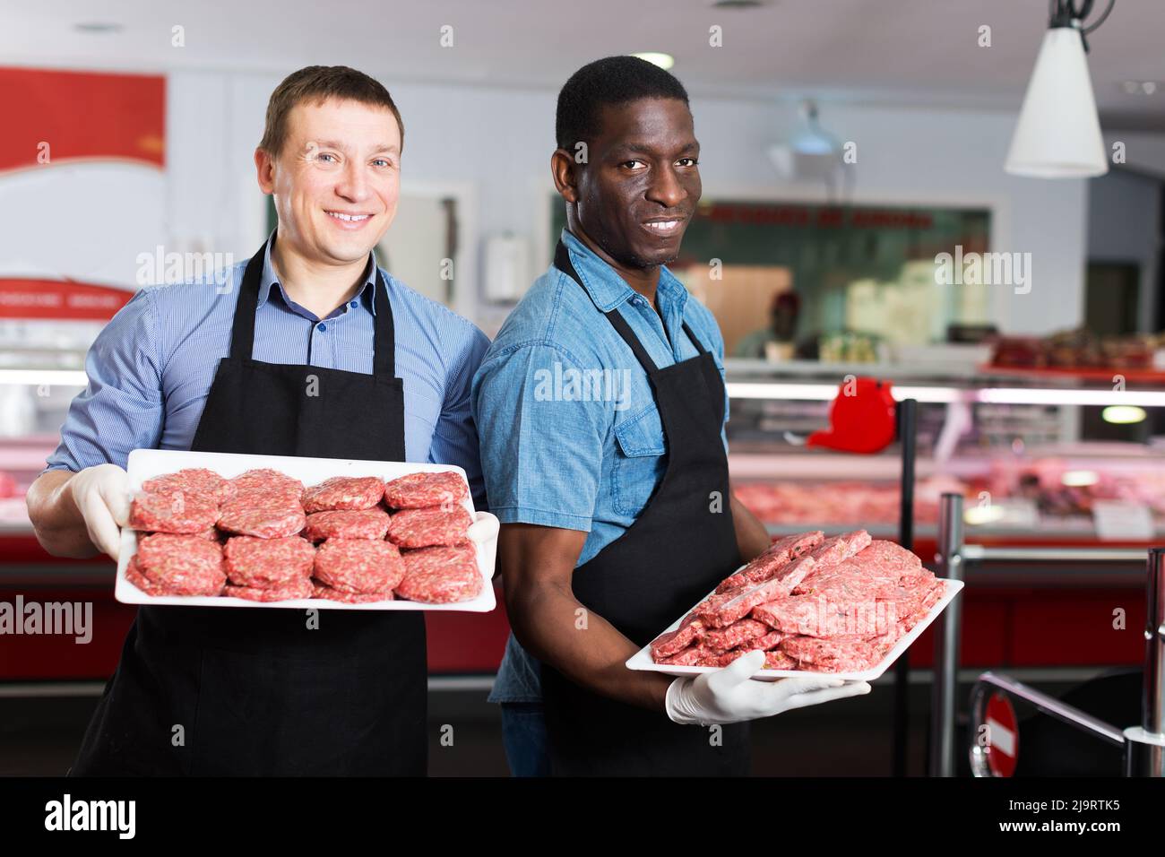 professional butchers standing in butcher shop with trays Stock Photo ...