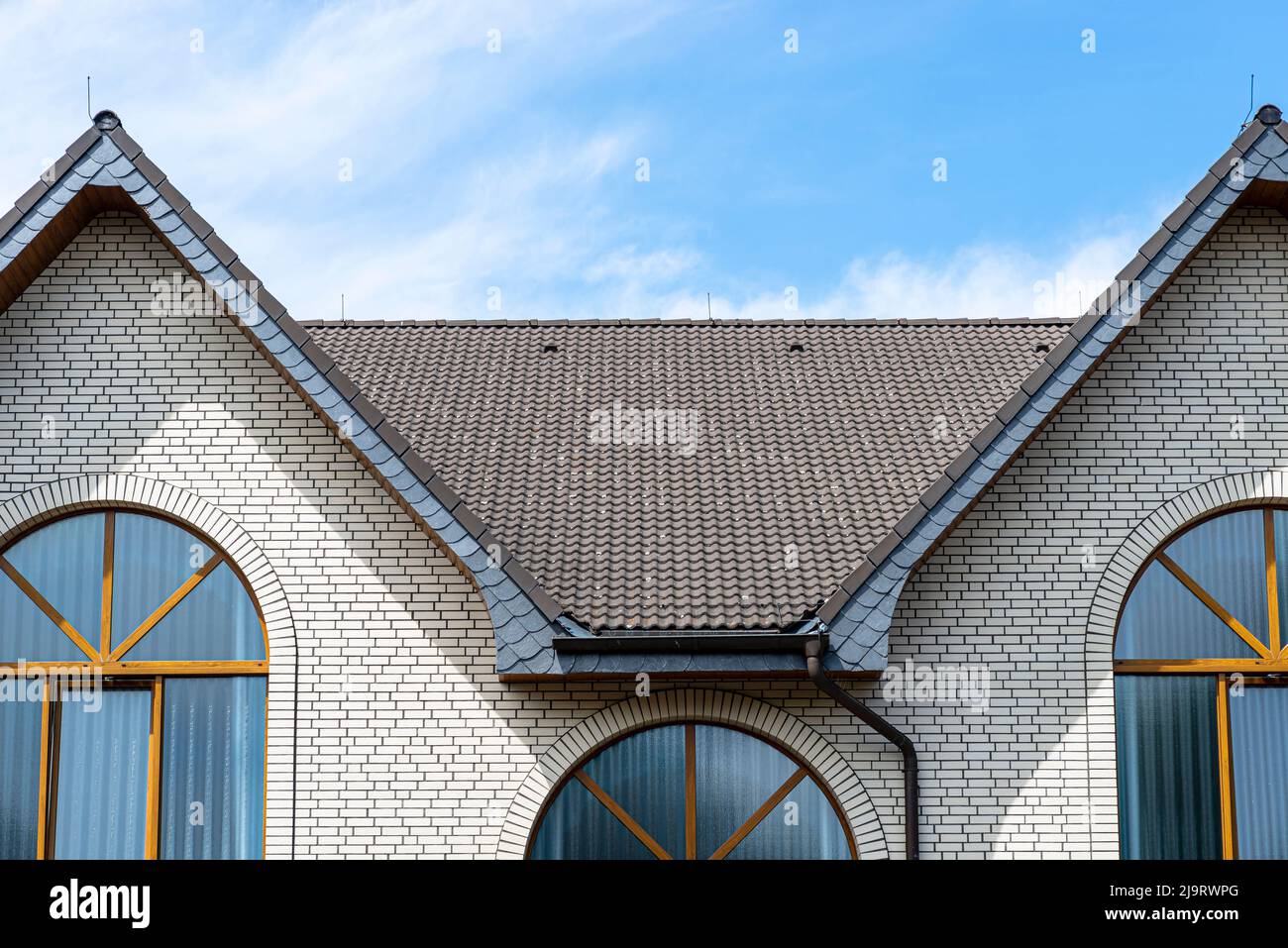 The church has a classic facade of white brick and a conical roof ...
