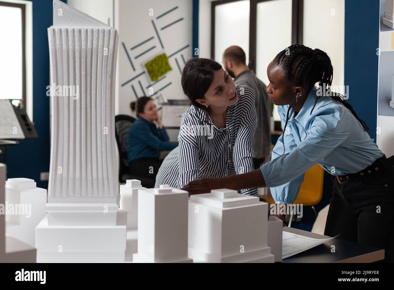 Professional architecture multi ethnic women working on blueprints and ...