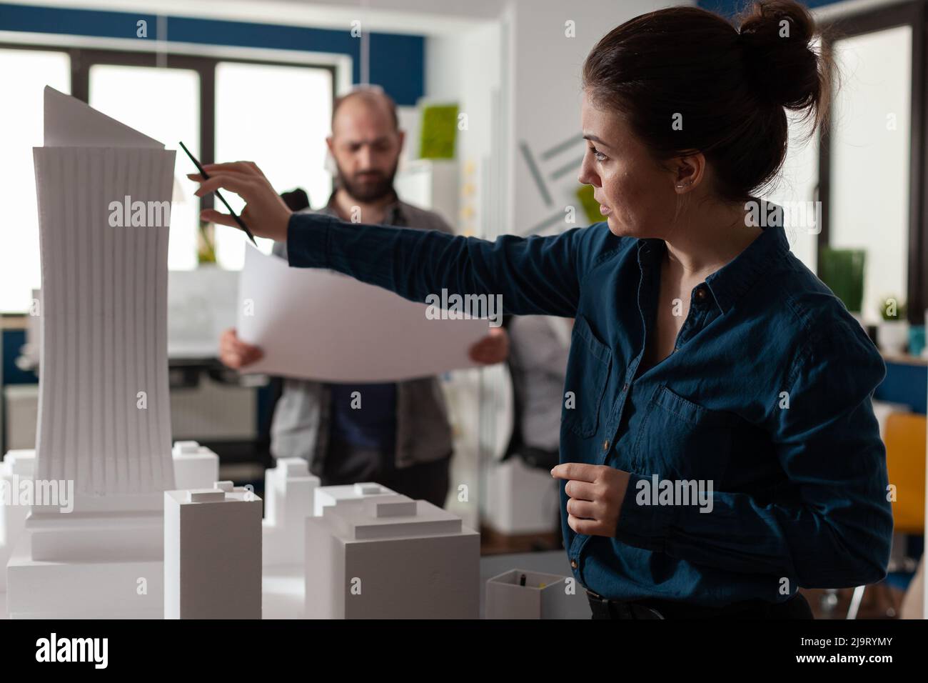 Architecture office partners looking at blueprints and plans for ...