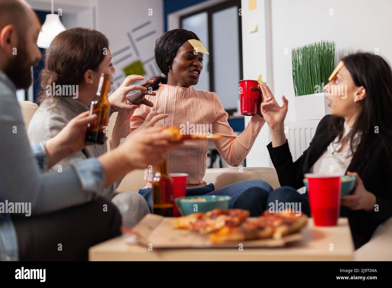 African american woman playing guessing game with friends after work at ...