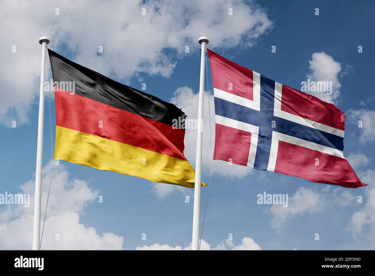 Germany and Norway two flags on flagpoles and blue cloudy sky ...