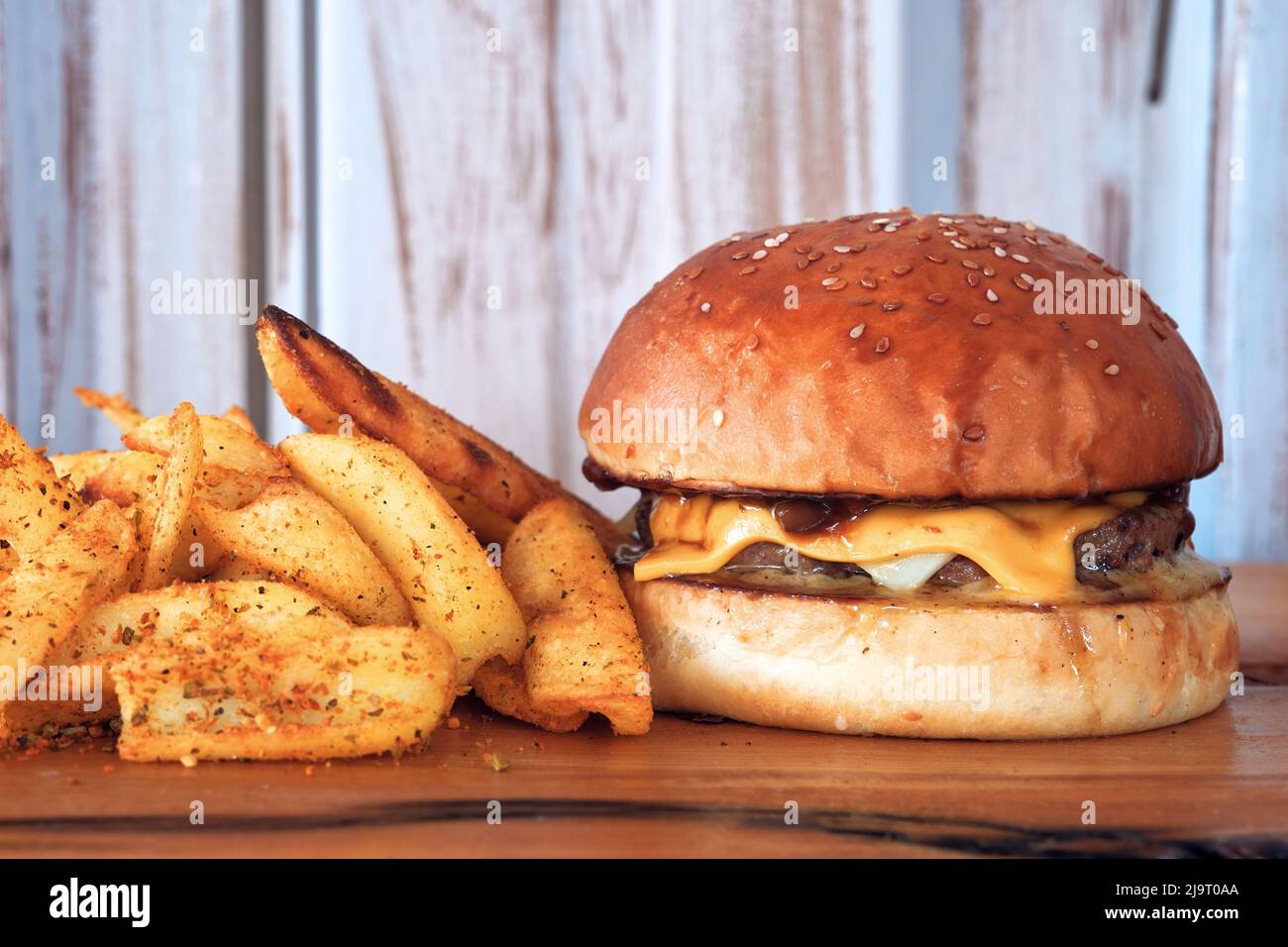 One hamburger, burger, or cheeseburger on wooden plate with French ...