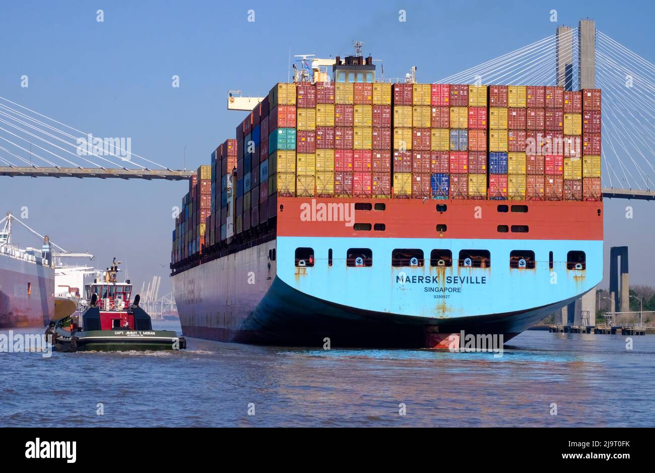 USA, Georgia, Savannah. Cargo ship entering Savannah Harbor escorted by ...