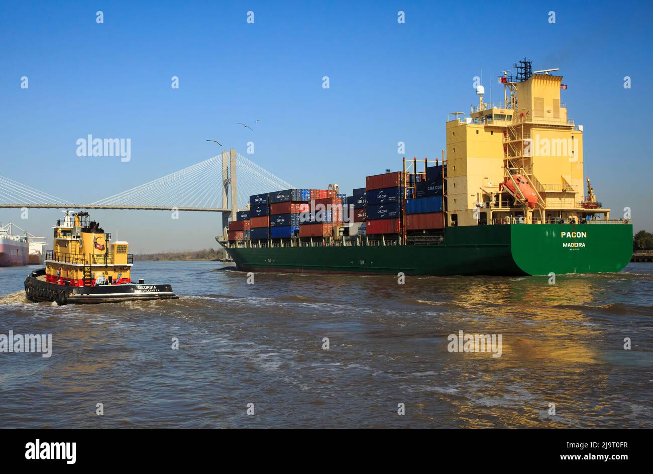USA, Georgia, Savannah. Cargo ship entering Savannah Harbor escorted by ...