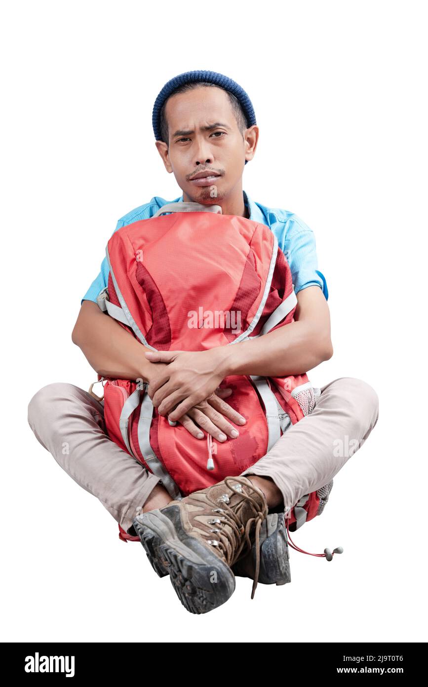 Asian man with a beanie hat hugging his a backpack sitting isolated ...