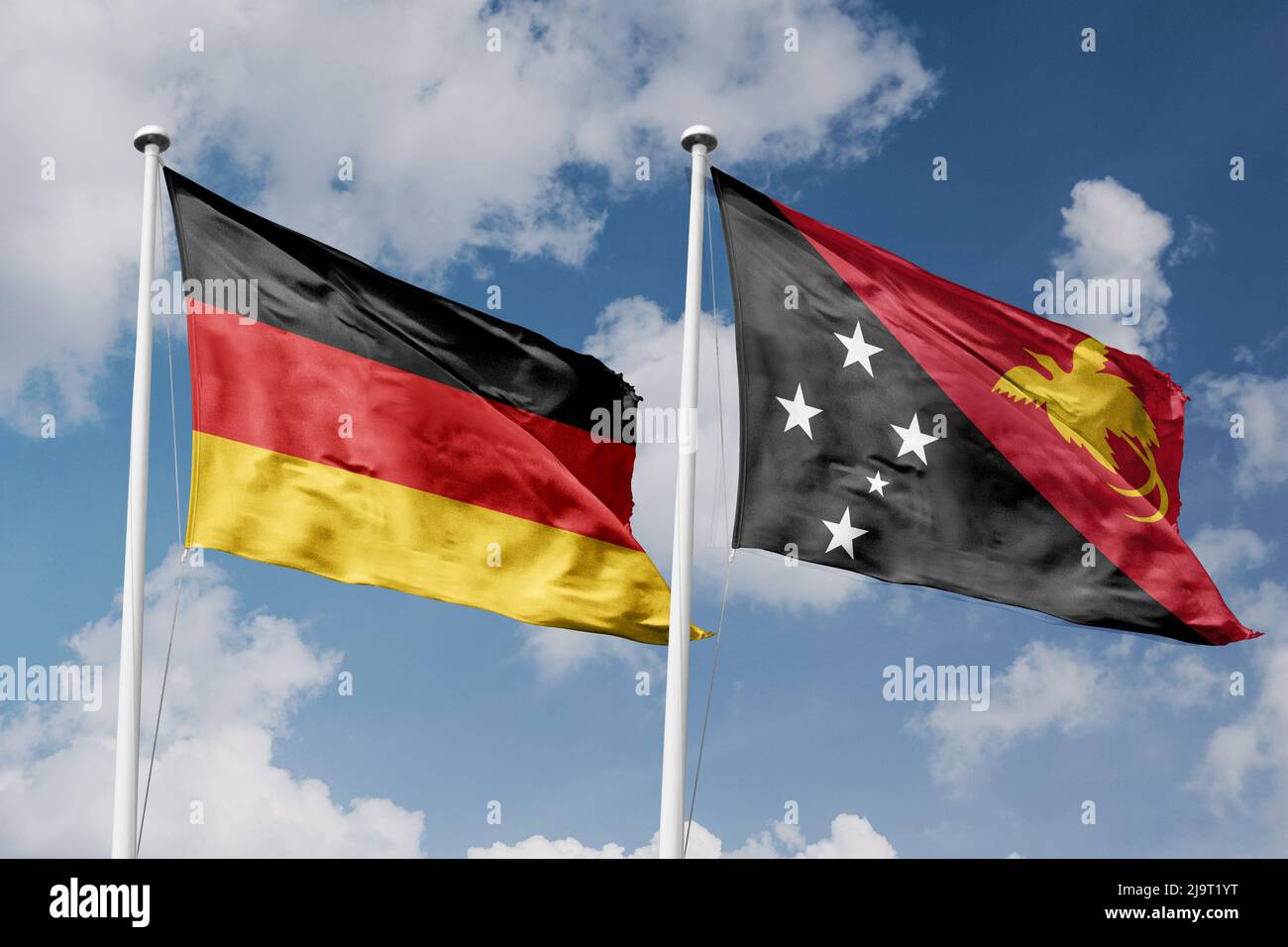Germany and Papua New Guinea two flags on flagpoles and blue cloudy sky ...