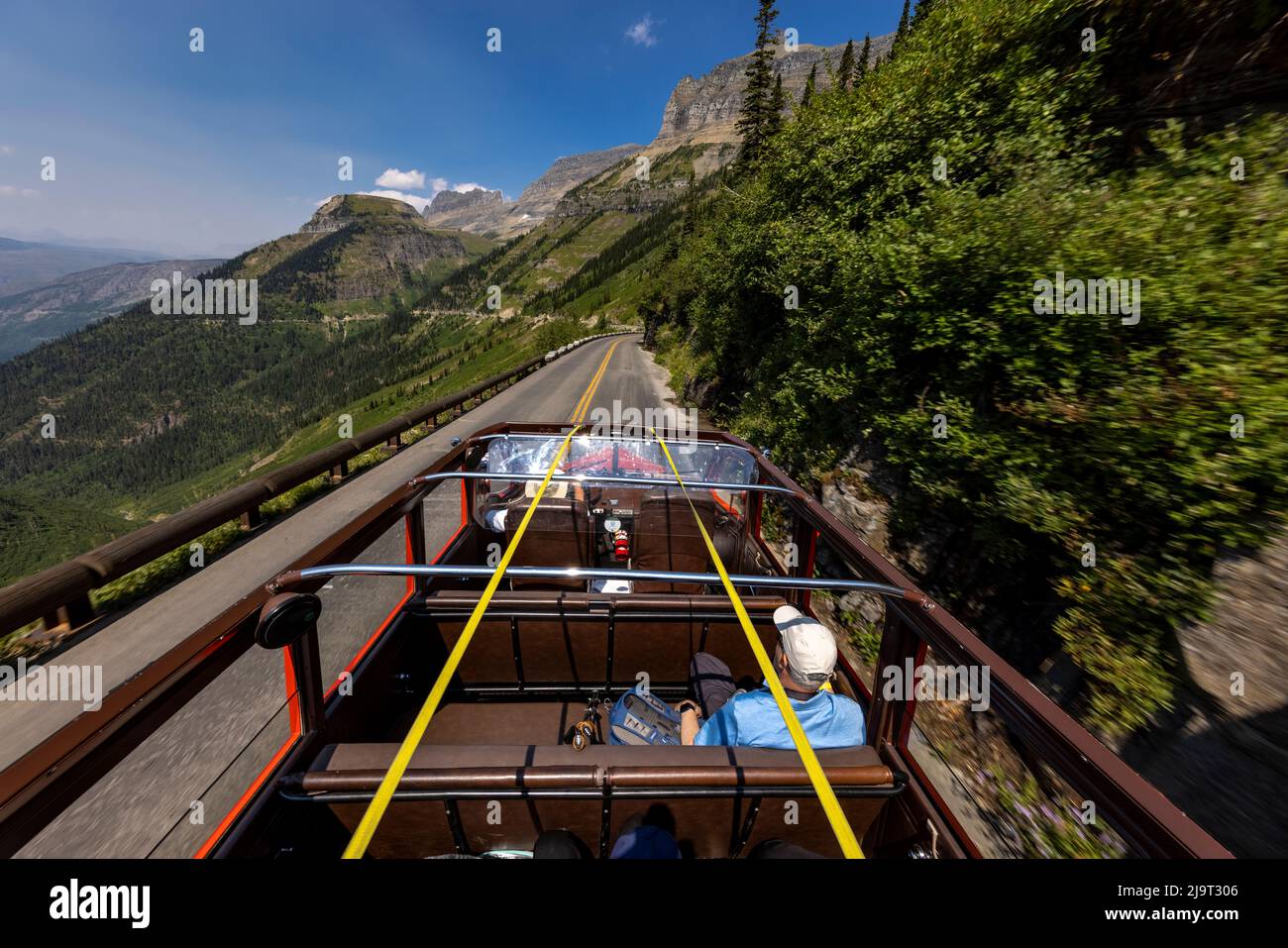 Iconic Red Jammer bus in motion in Glacier National Park, Montana, USA ...