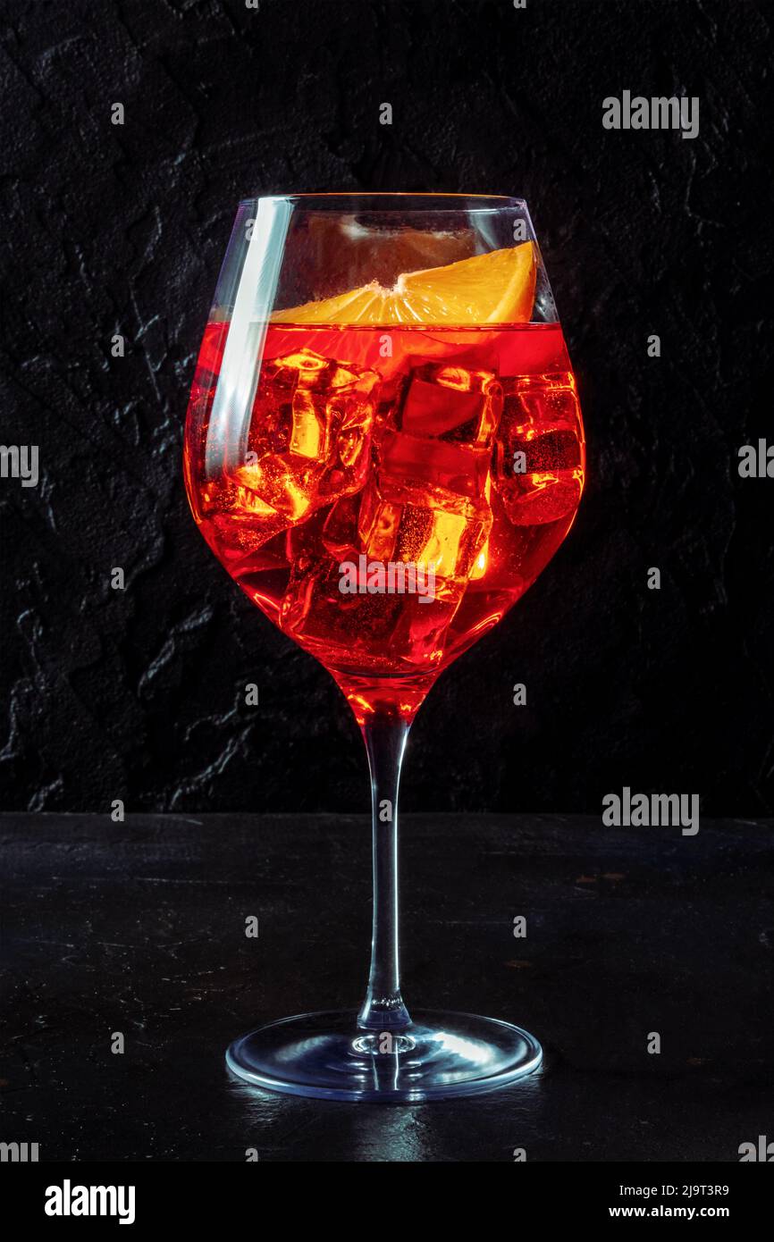 Aperol cocktail with an orange slice, a side view on a dark background ...