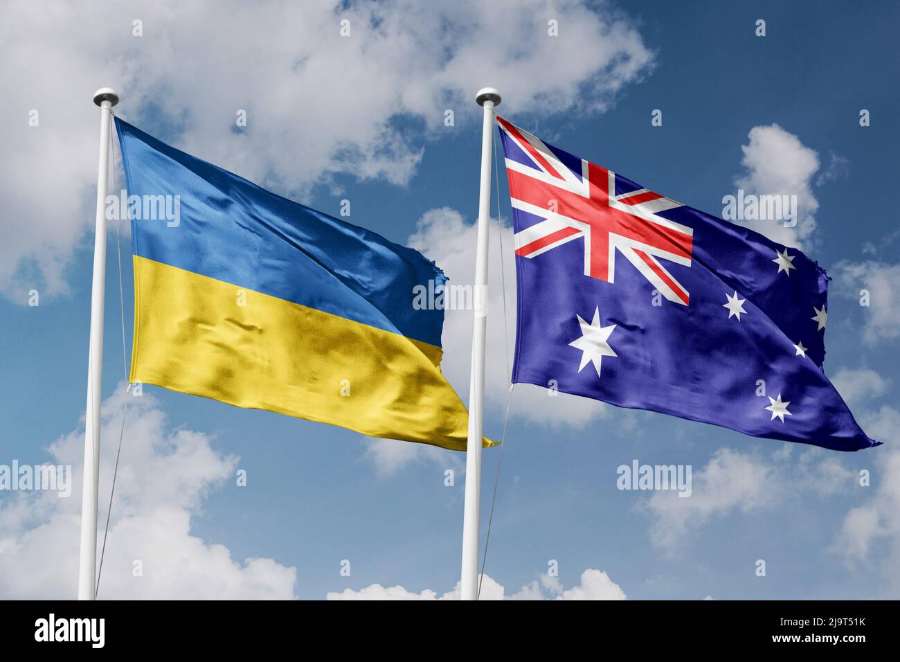 Ukraine and Australia two flags on flagpoles and blue cloudy sky ...