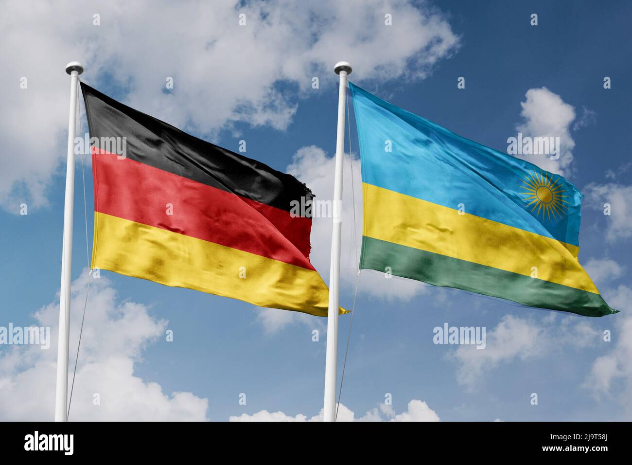 Germany and Rwanda two flags on flagpoles and blue cloudy sky ...