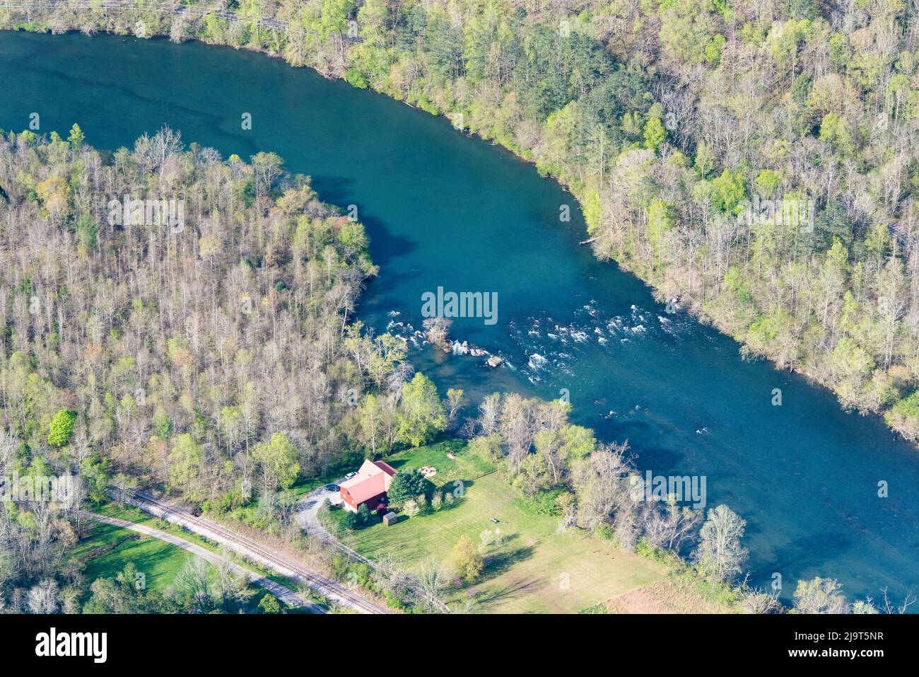 USA, Tennessee. Remote home on Hiwassee River. Rock shoals create ...