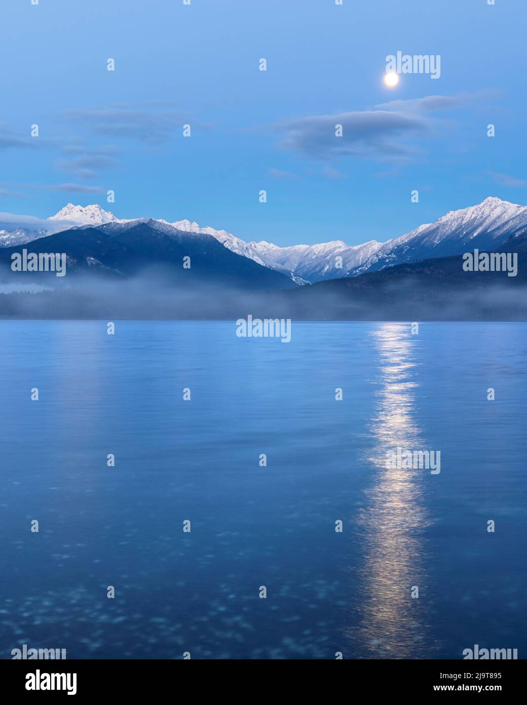 USA, Washington State, Seabeck. Moon setting over the Olympic Mountains ...
