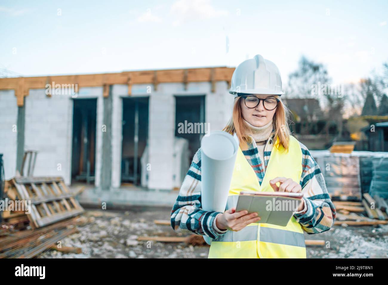 young engineer girl in a protective uniform at a construction site ...