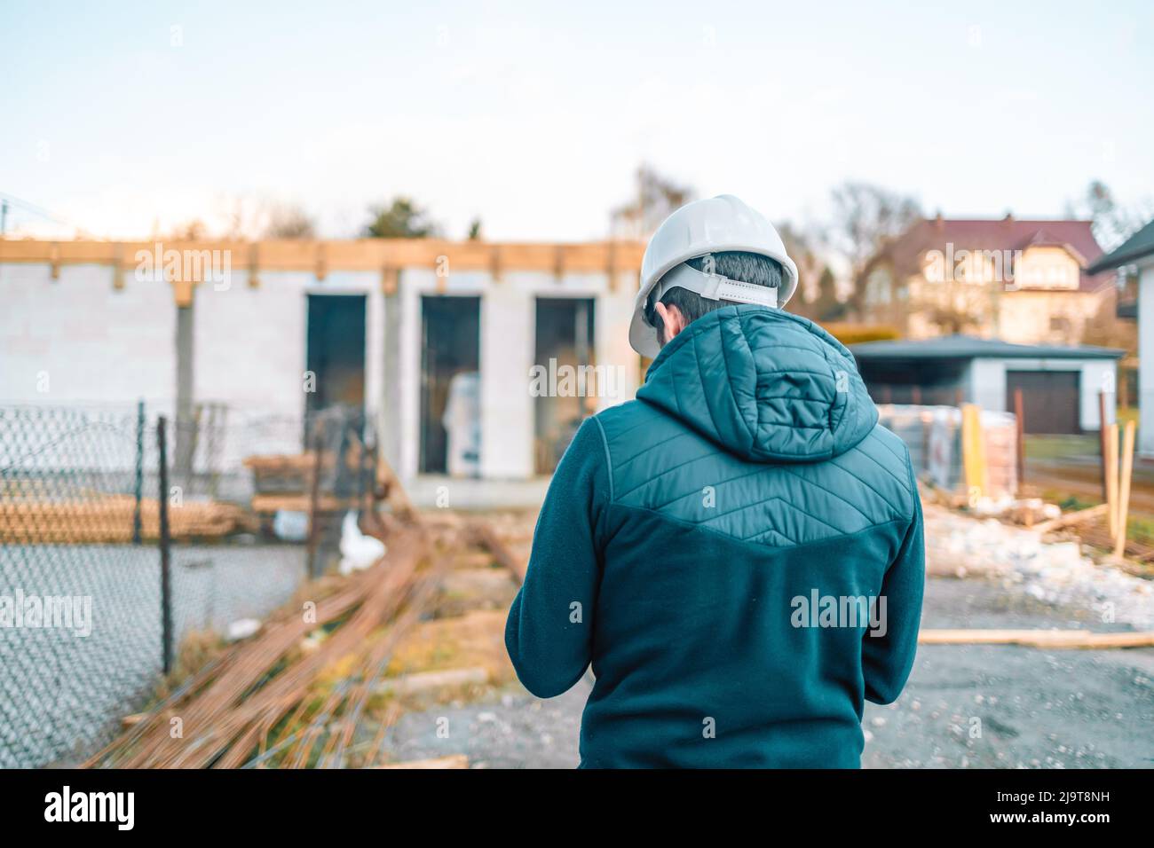 40s bearded engineer worker with helmet on head standing outside of ...