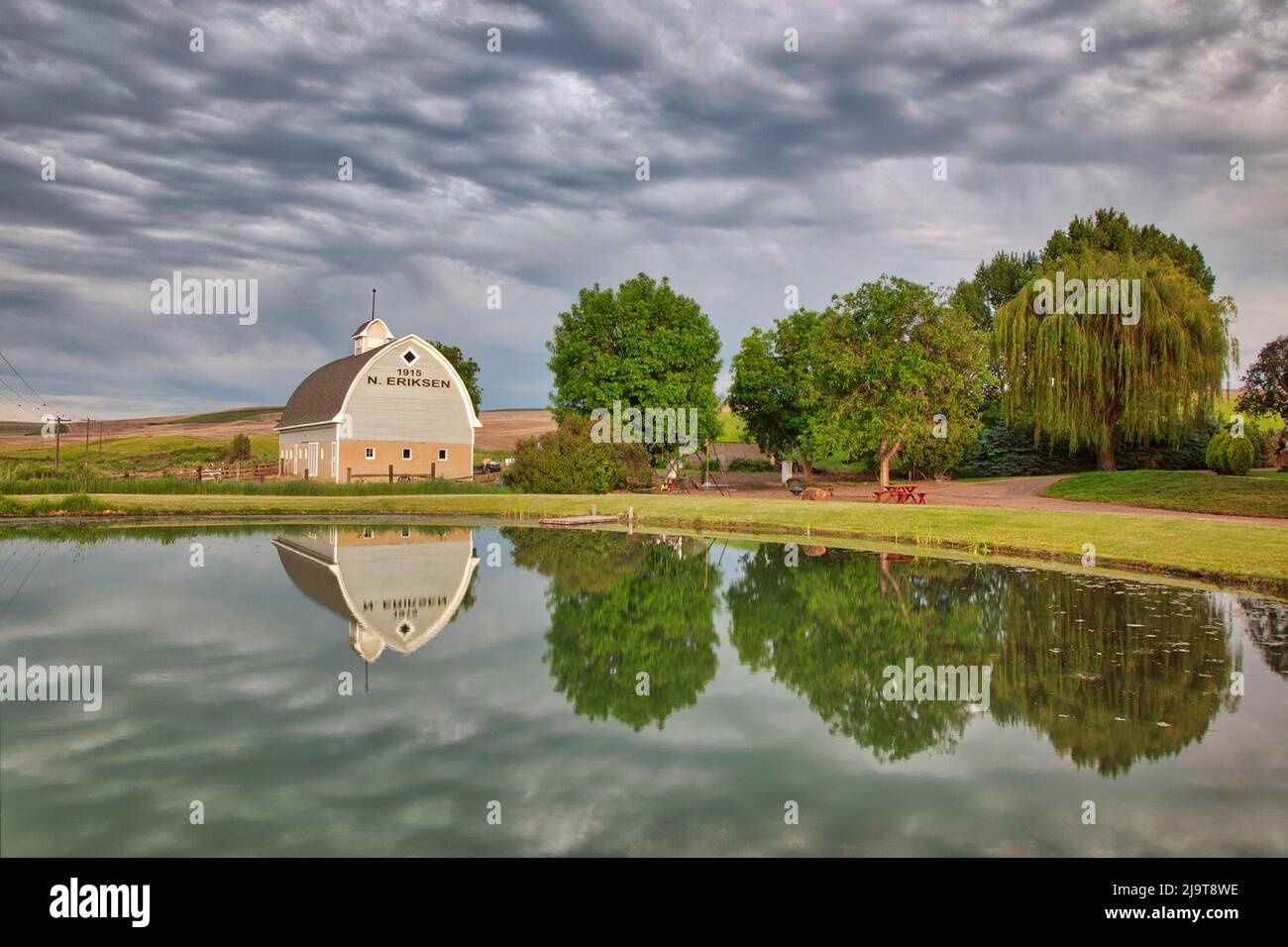 USA, Washington State, Palouse. Reflection of the Erickson barn in pond ...