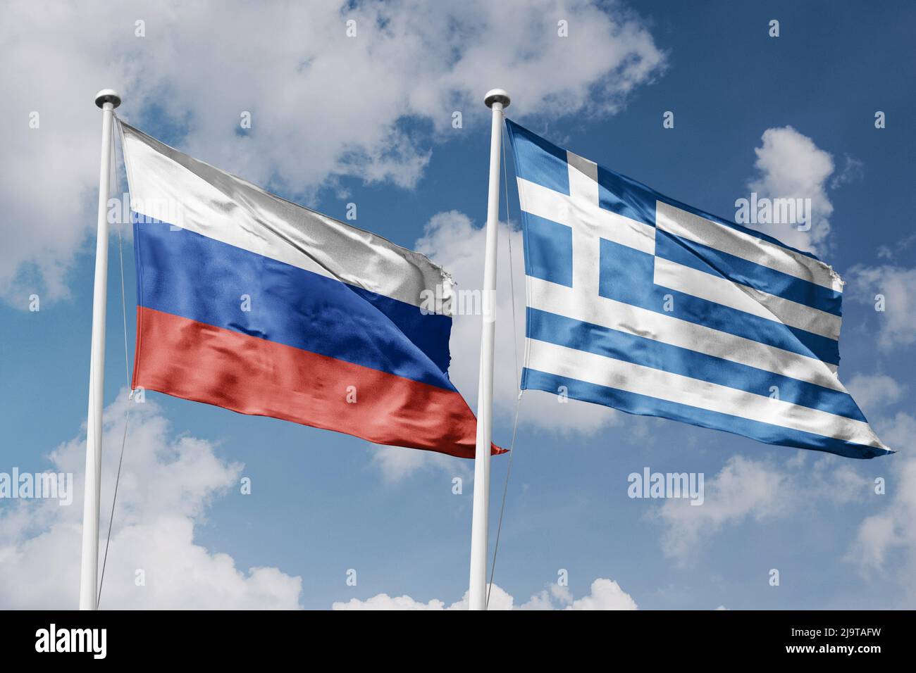 Russia and Greece two flags on flagpoles and blue cloudy sky background ...
