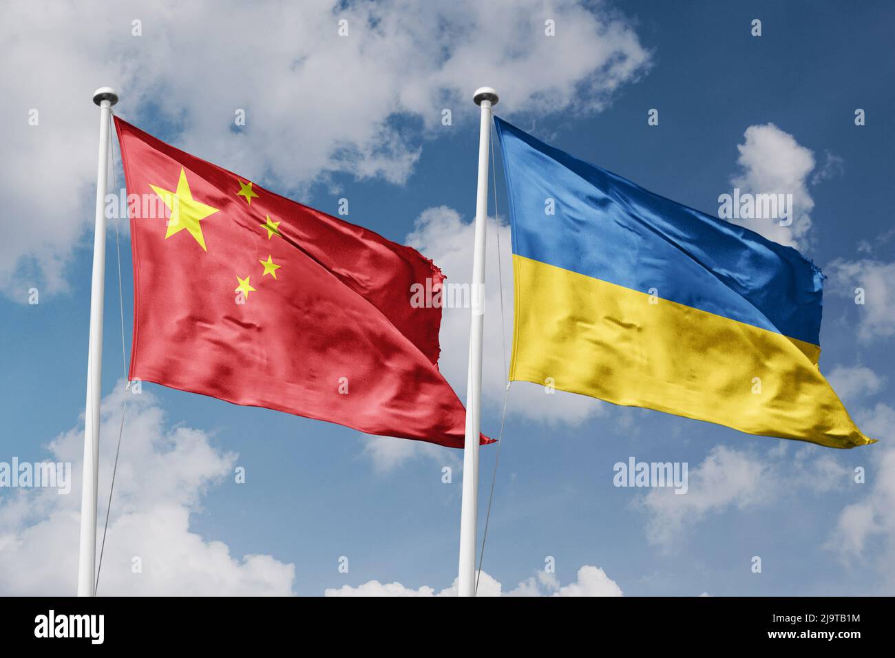 China and Ukraine two flags on flagpoles and blue cloudy sky background ...