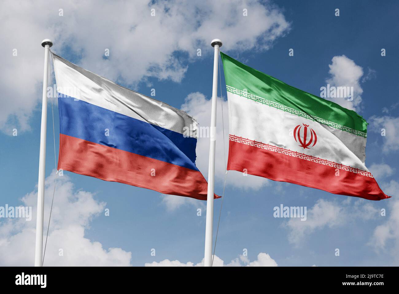 Russia and Iran two flags on flagpoles and blue cloudy sky background ...