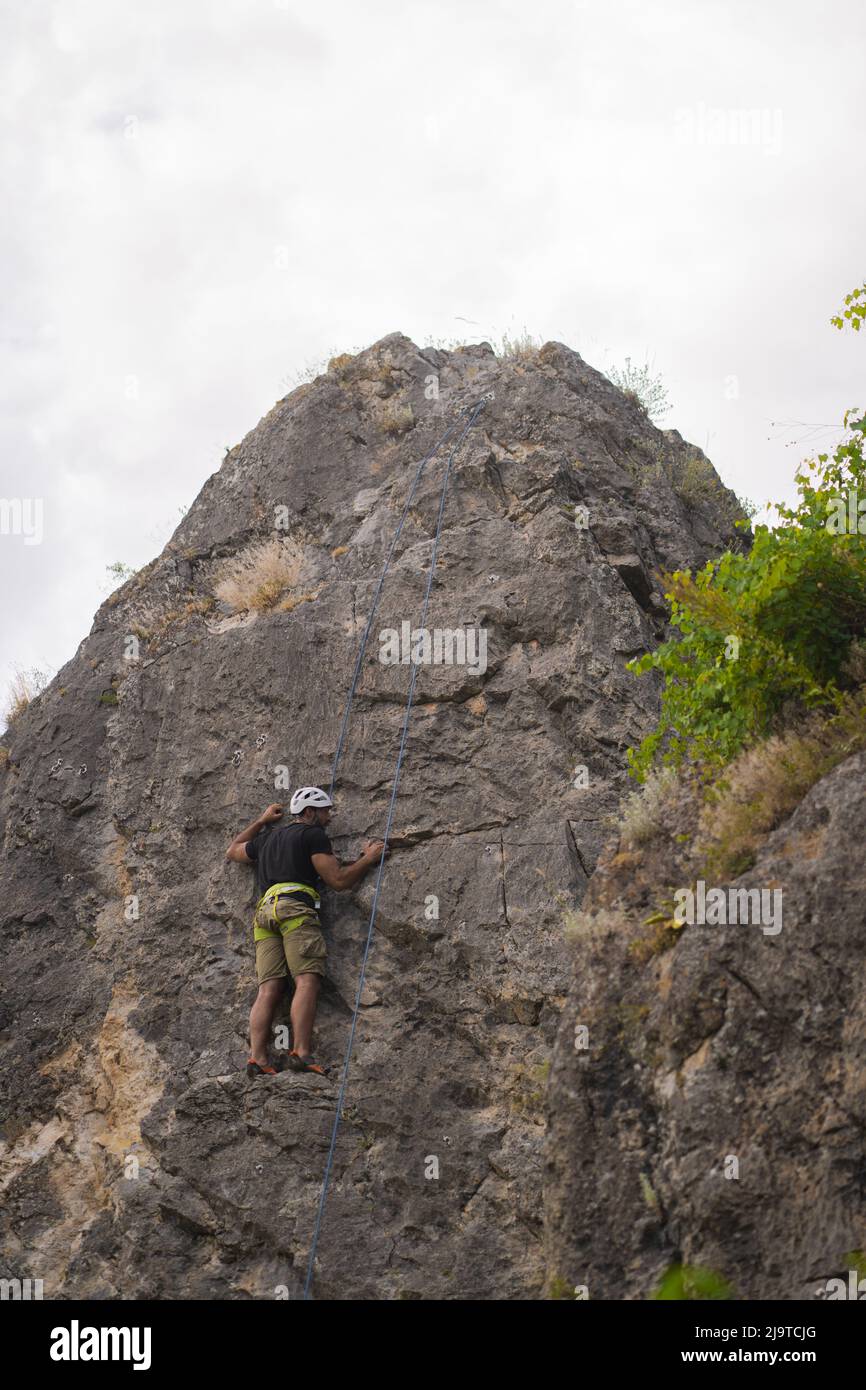 Handsome and fit guy is climbing while thinking a lot about the next ...