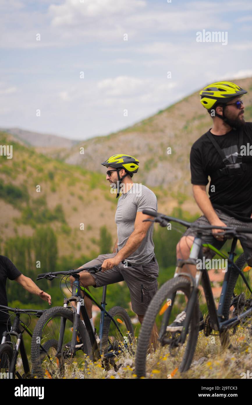 Group of friends are taking a break together on the top of the mountain ...