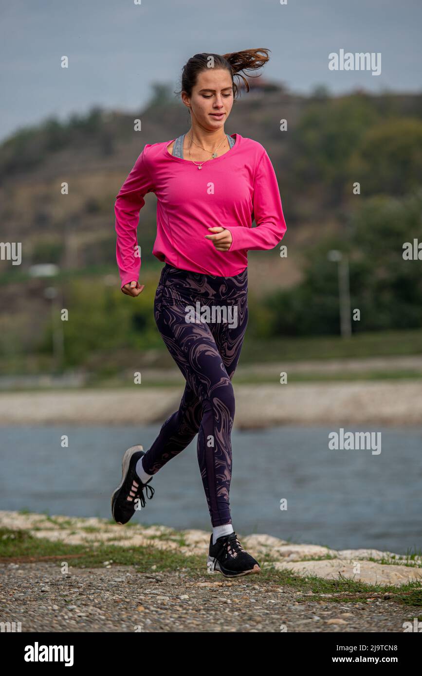 Attractive and beautiful girl is running fast while looking down, near ...