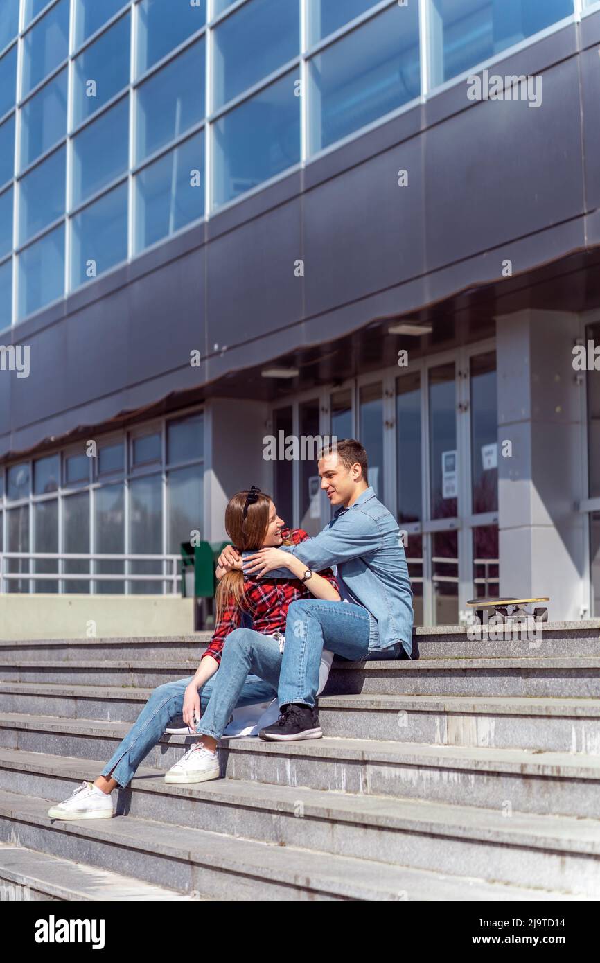 Cute couple hugging while sitting ont the stairs Stock Photo - Alamy