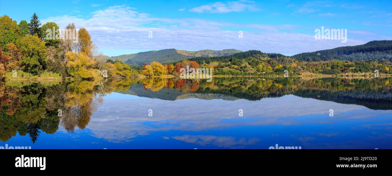Autumn trees and clouds reflected in the waters of beautiful Lake ...