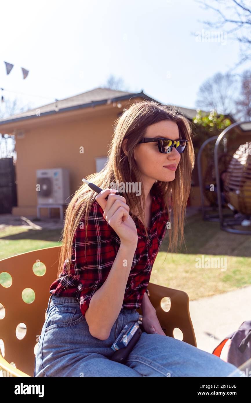 Cute girl is smoking while sitting in the cafe Stock Photo - Alamy