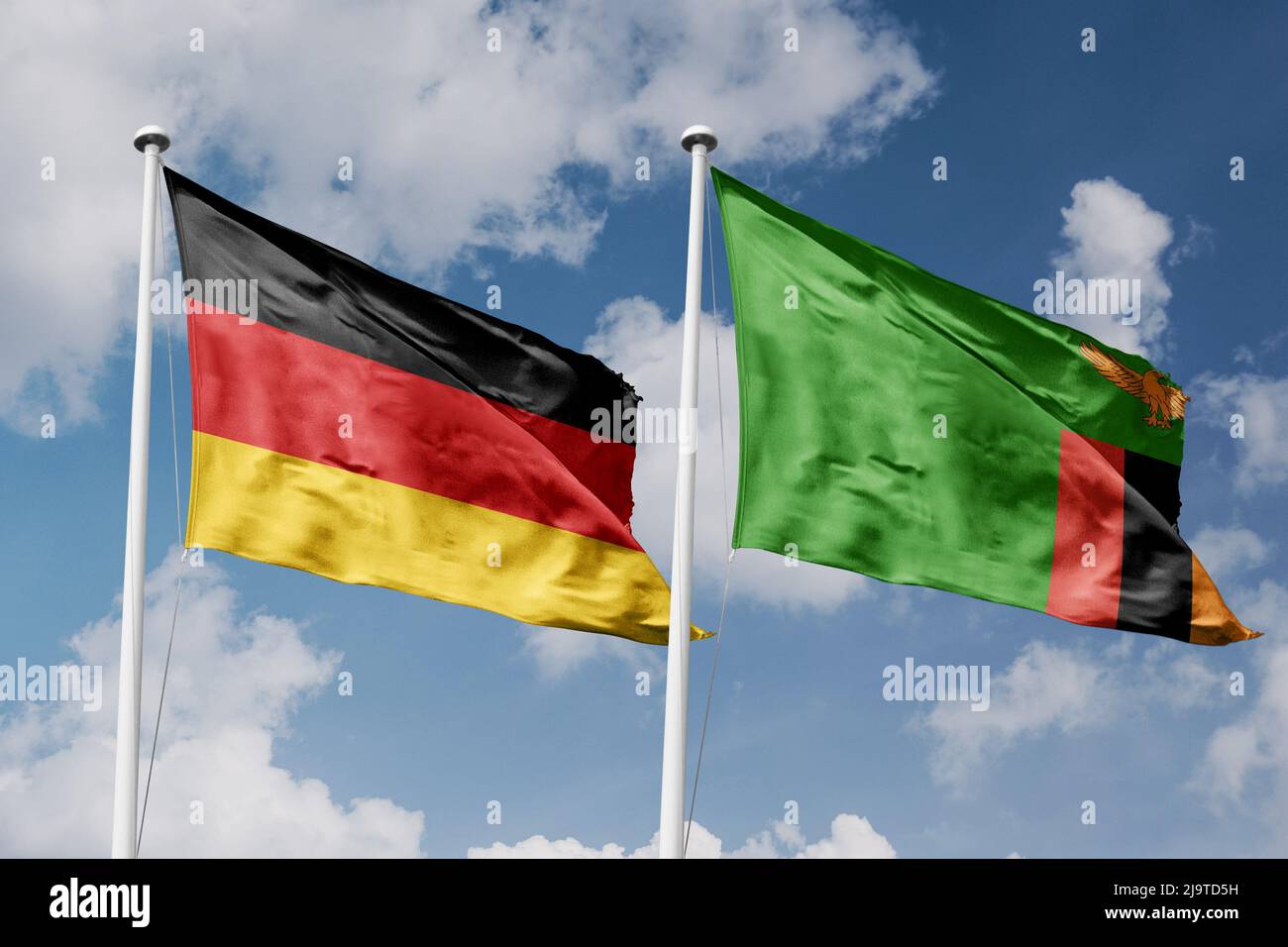 Germany and Zambia two flags on flagpoles and blue cloudy sky ...