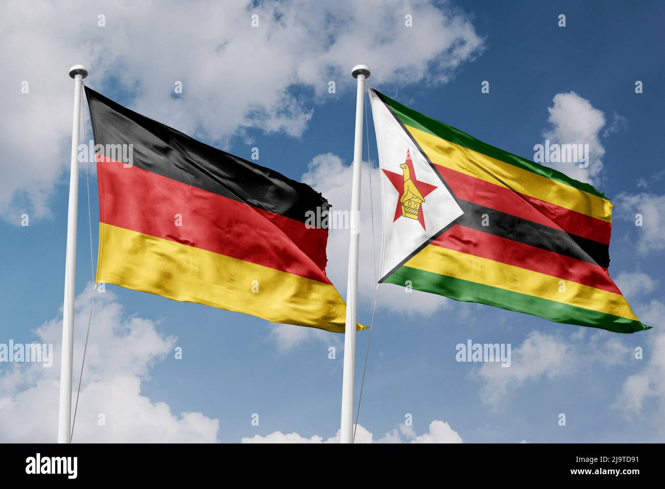 Germany and Zimbabwe two flags on flagpoles and blue cloudy sky ...