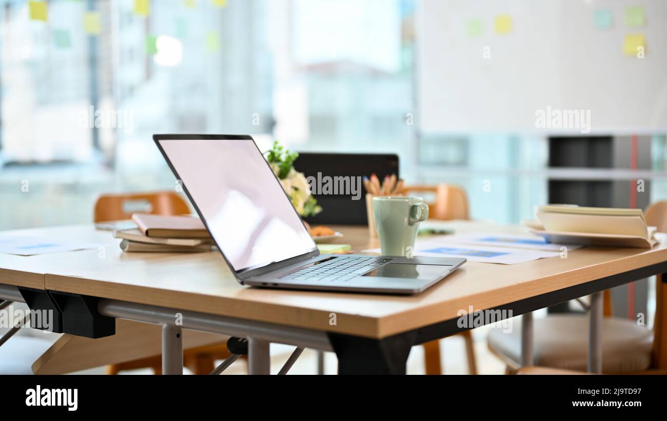 Modern office desk with notebook laptop computer, coffee cup, and ...