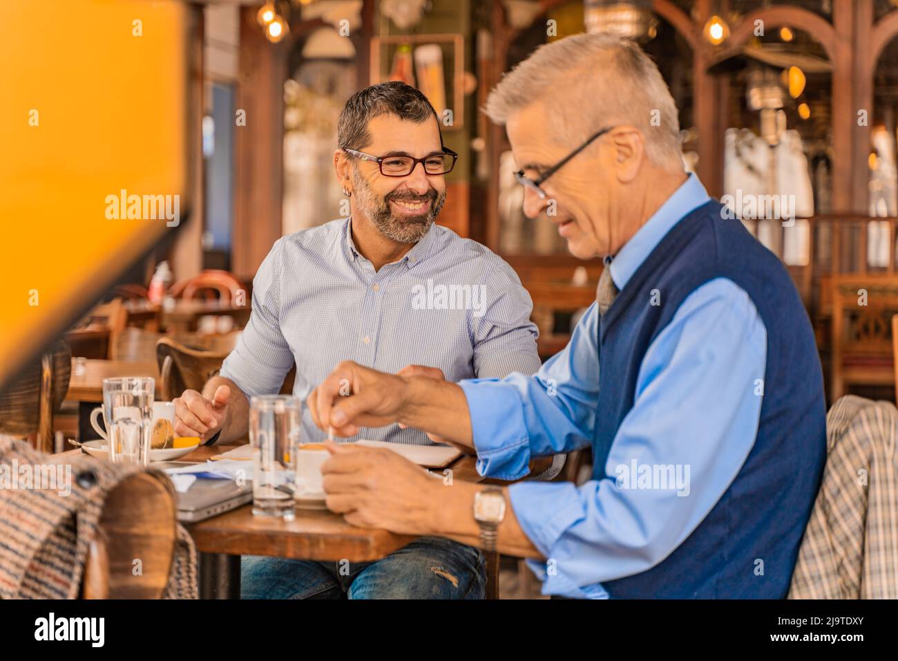 Two senior businessmen are laughing while taking their coffee Stock ...