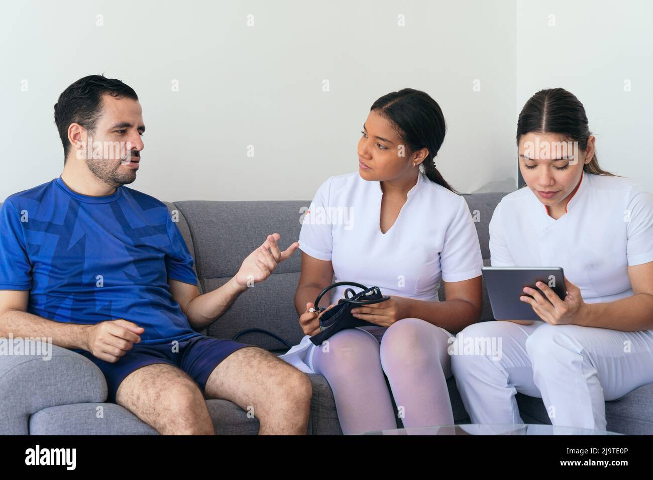 Nurses checking a man's blood pressure at home Stock Photo - Alamy
