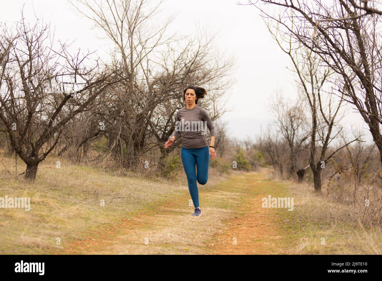 Middle aged woman is running in the mountain Stock Photo - Alamy